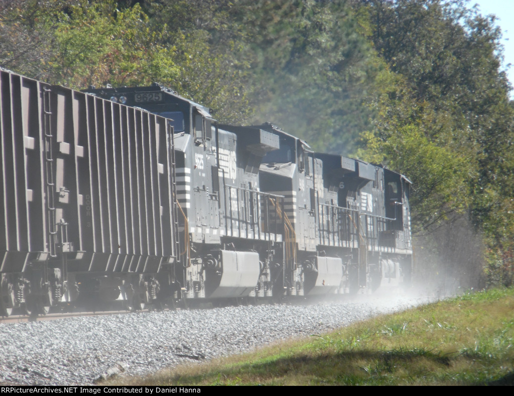 Train kicks up dust from the newly laid ballast